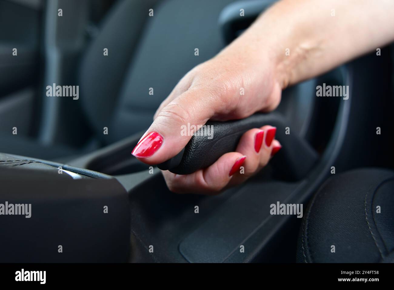 Hand female driver pulling the hand brake inside car Stock Photo - Alamy