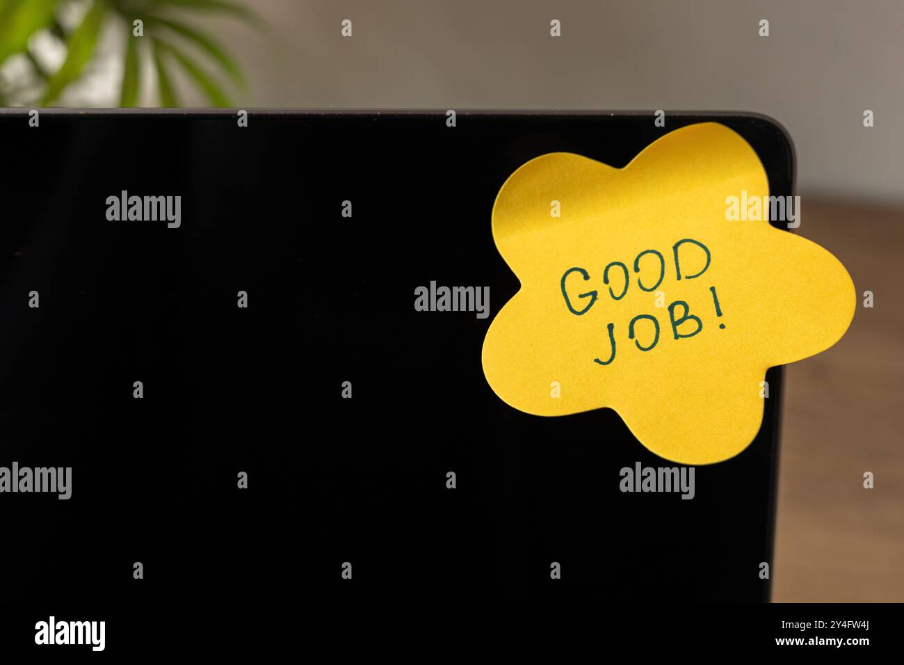 Bright yellow sticky note with cheerful message on a laptop in a cozy ...