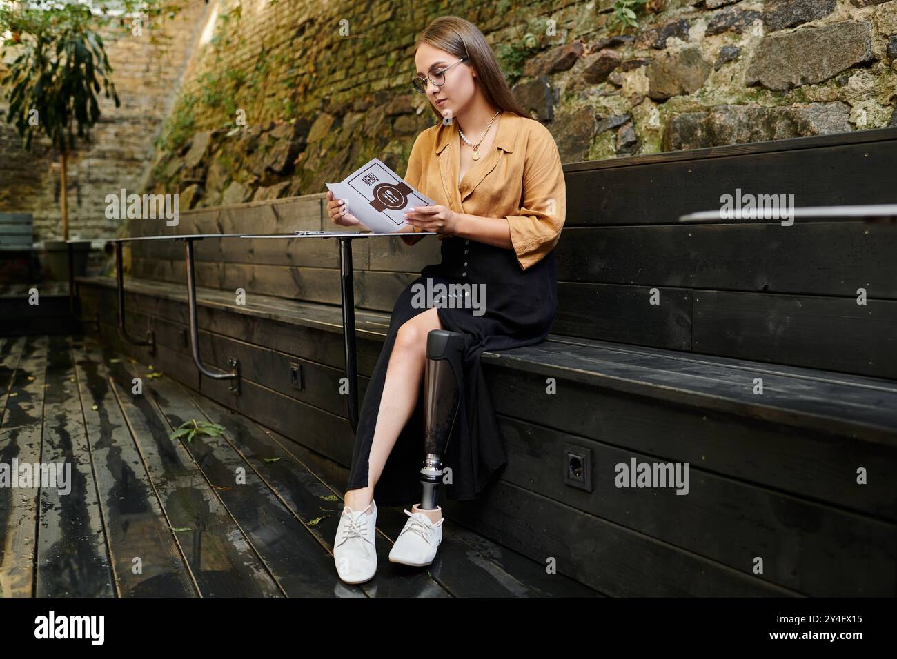 In a charming cafe, a young woman with a prosthetic leg reads a menu ...