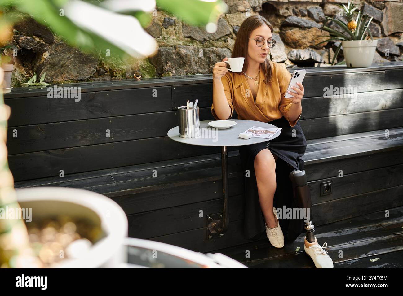 A young woman relaxes in a charming cafe, sipping coffee and checking ...