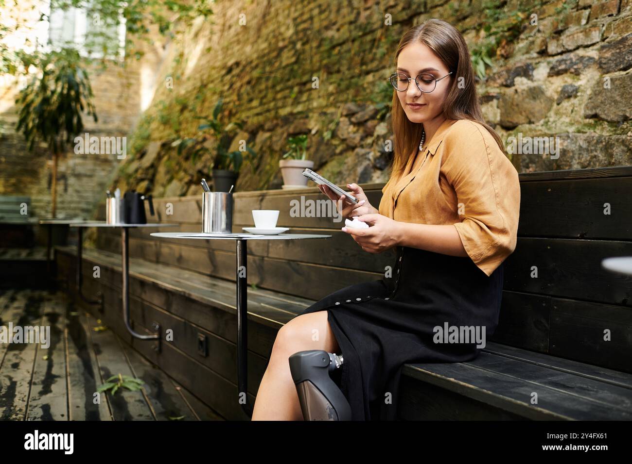 A young woman relaxes in a cozy cafe, engaging with her smartphone ...