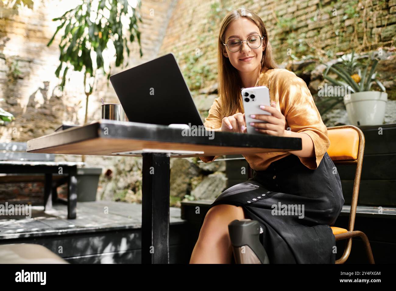 Sitting comfortably in a cafe, a young woman with a prosthetic leg ...
