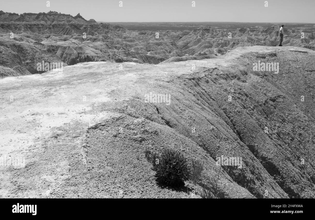 A Caucasian man standing on a hill, enjoying the breathtaking landscape ...