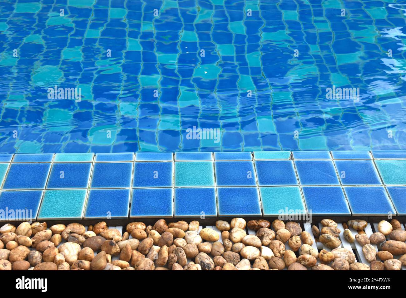 water flowing to edge of blue tile swimming pool Stock Photo - Alamy