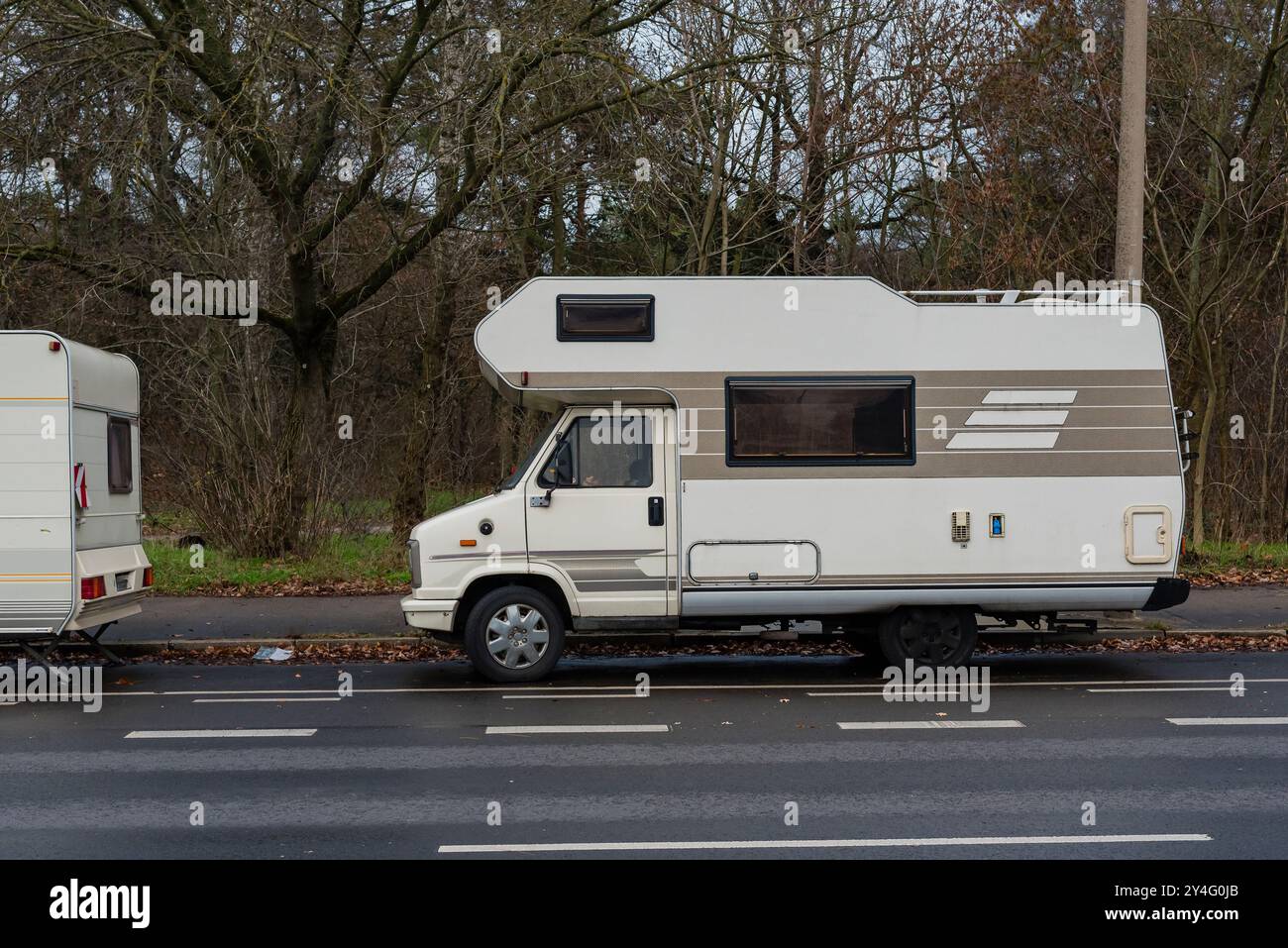 An old motor home from the 90s parked on the side of the road, side ...