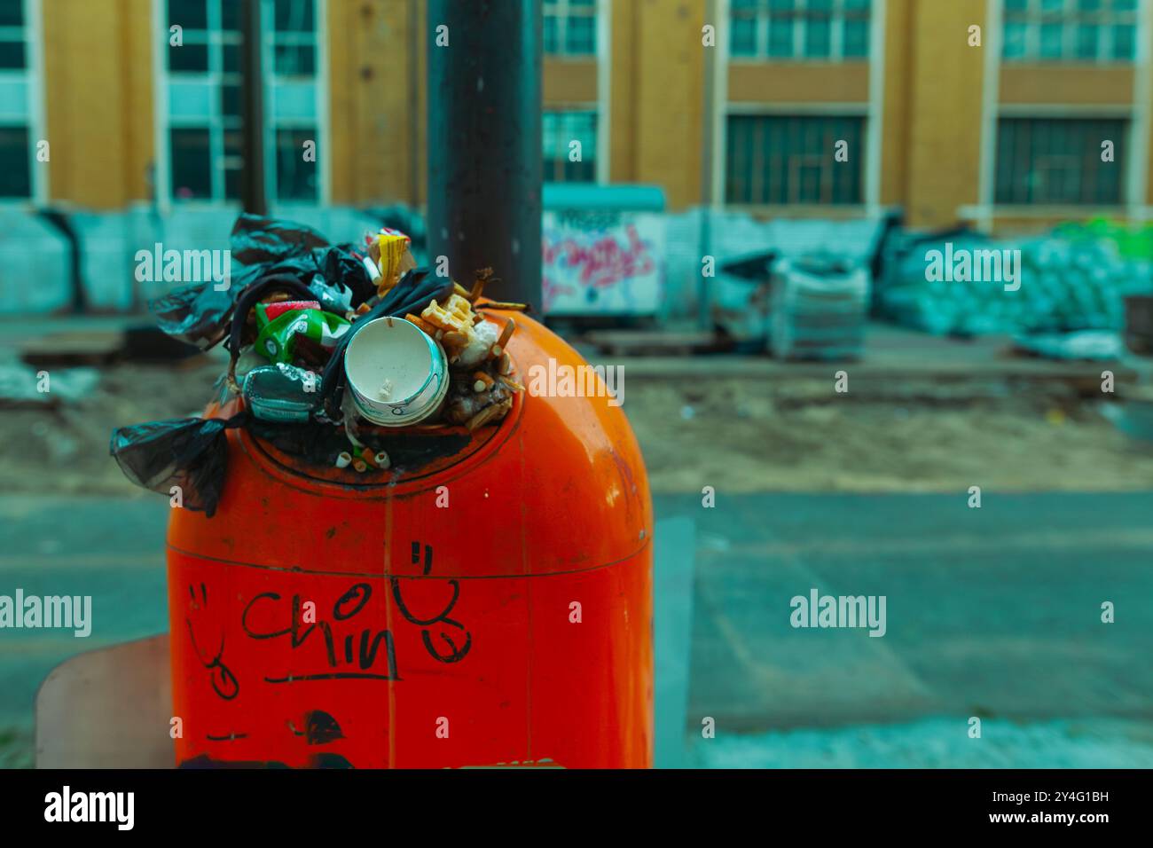 An overfilled trash can with a lot of garbage sticking out of the ...