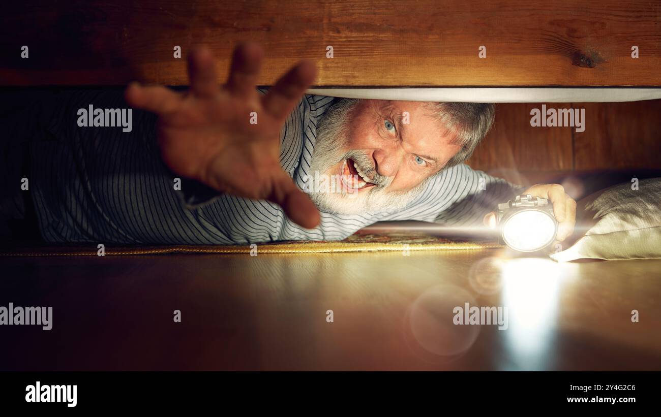 Horror. Emotional elderly man with terrifying emotions, looking under ...