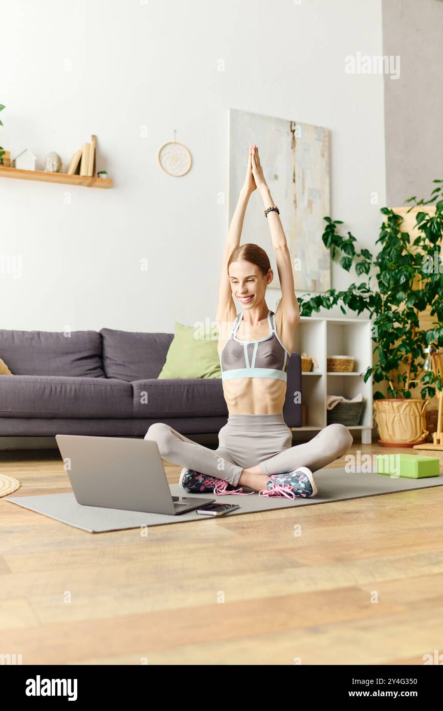 A dedicated young woman with anorexia stretches and practices yoga in her living room, focusing ...