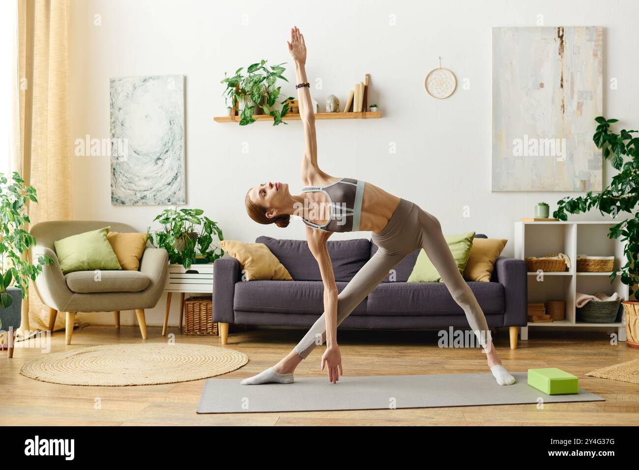 A dedicated young woman with anorexia focuses on her home workout ...