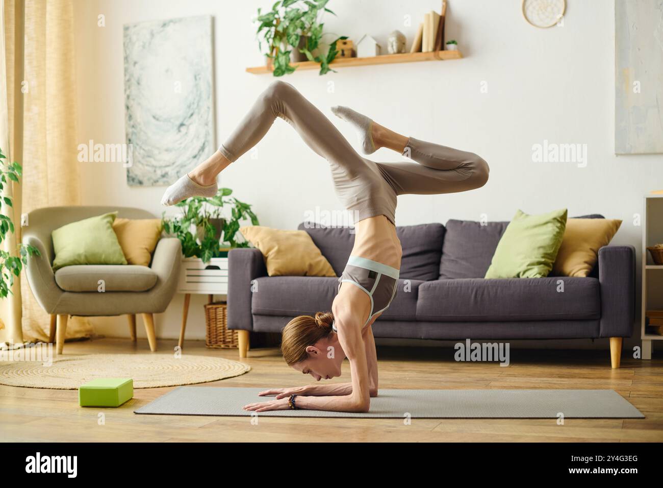A young woman with anorexia engages in yoga at home, showcasing ...