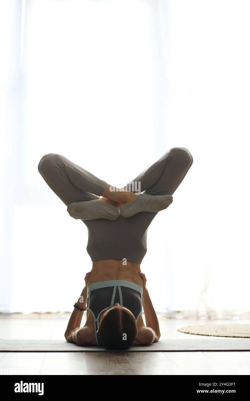 In a serene home setting, a young woman with anorexia practices yoga, focusing on her well-being ...