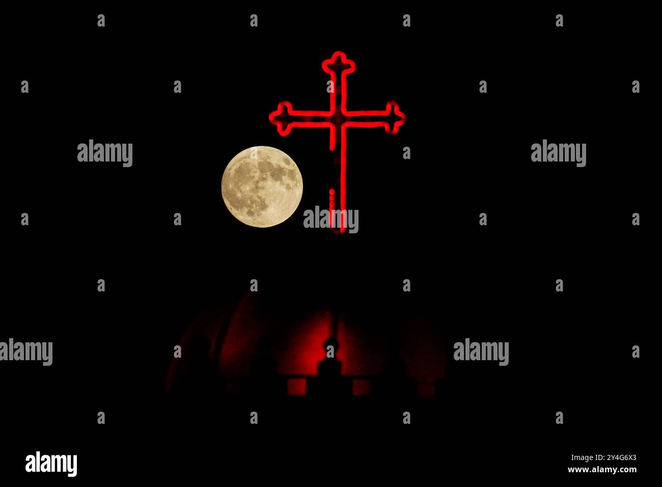Aqosh, Iraq. 17th Sep, 2024. The full moon rises behind the cross of ...