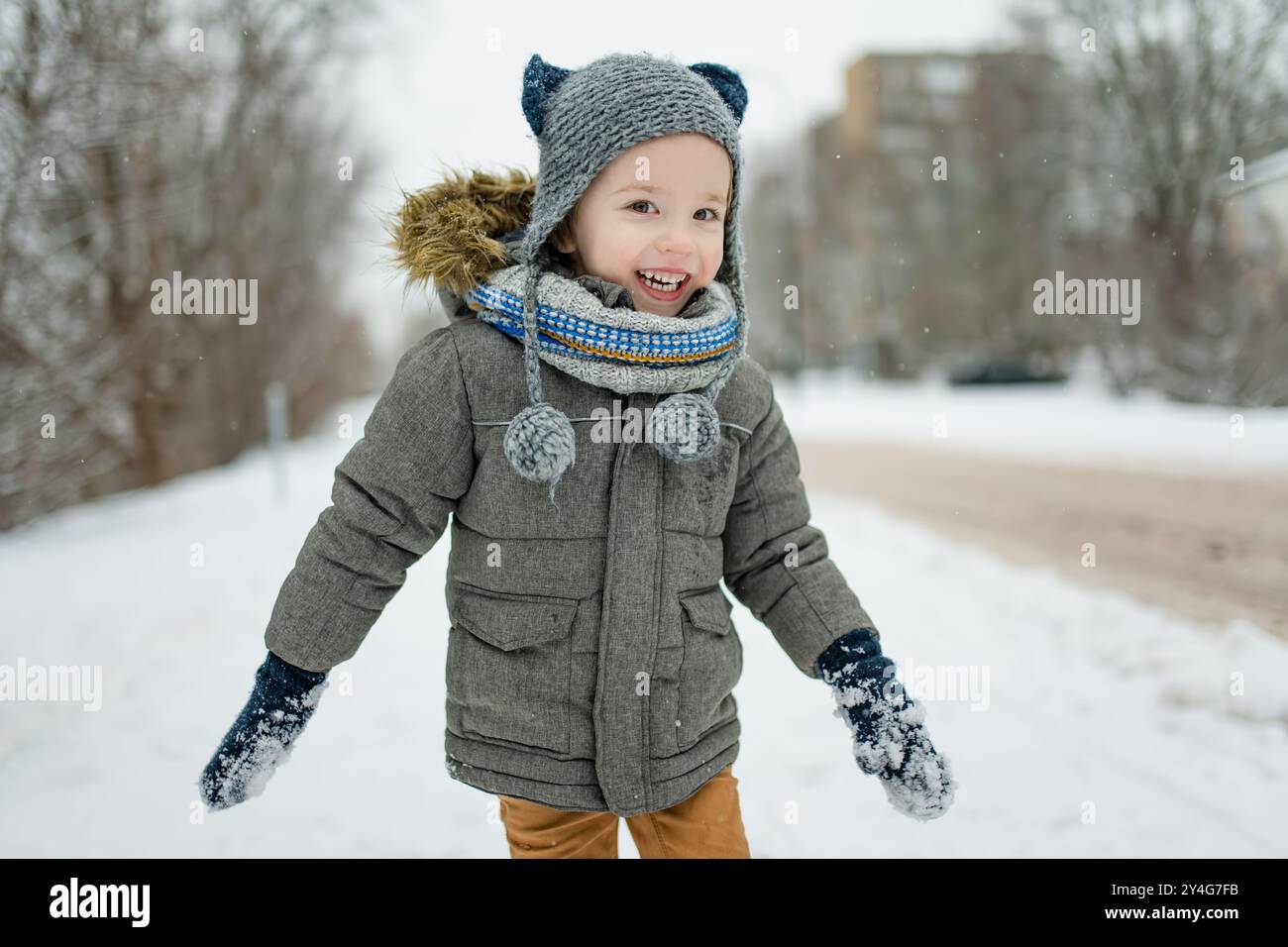 Adorable little boy having fun on snowy winter day. Cute child wearing ...