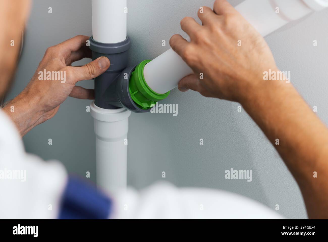 plumber at work. installing PVC drain pipes. plumbing services Stock ...