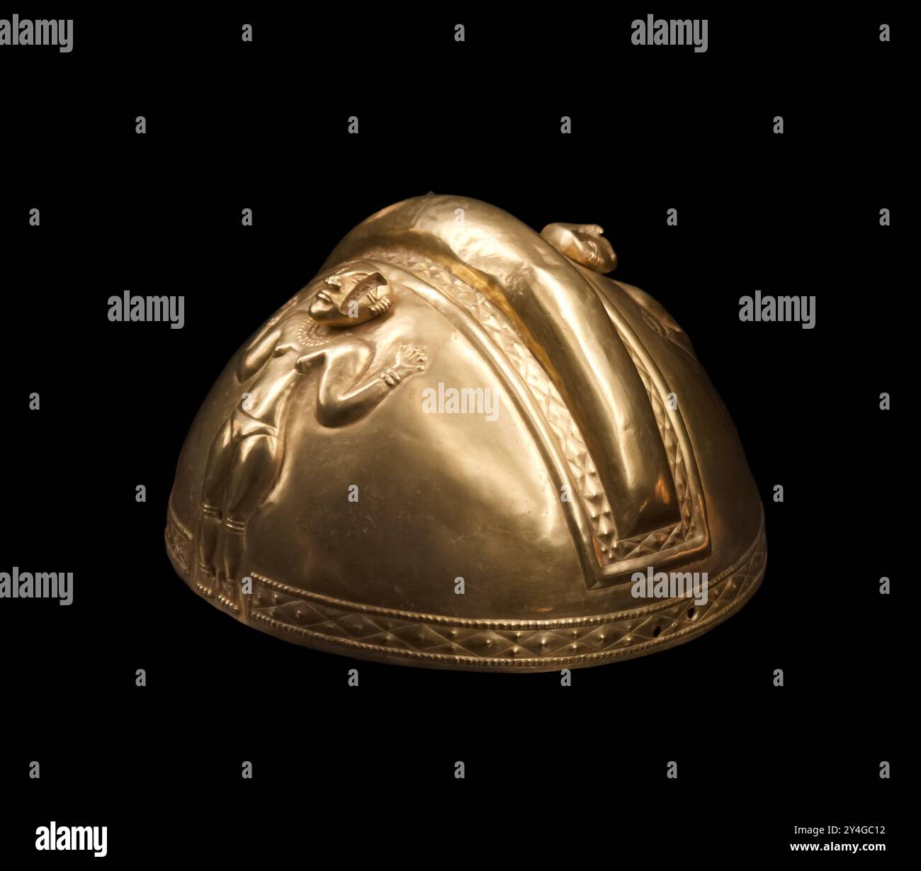 old gold antique Indian helmet from South America on a black background ...