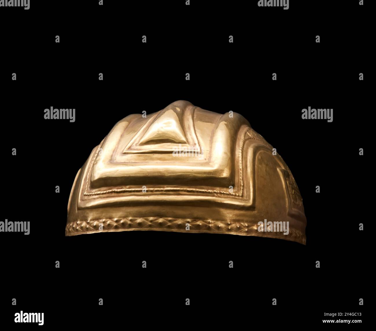 old gold antique Indian helmet from South America on a black background ...
