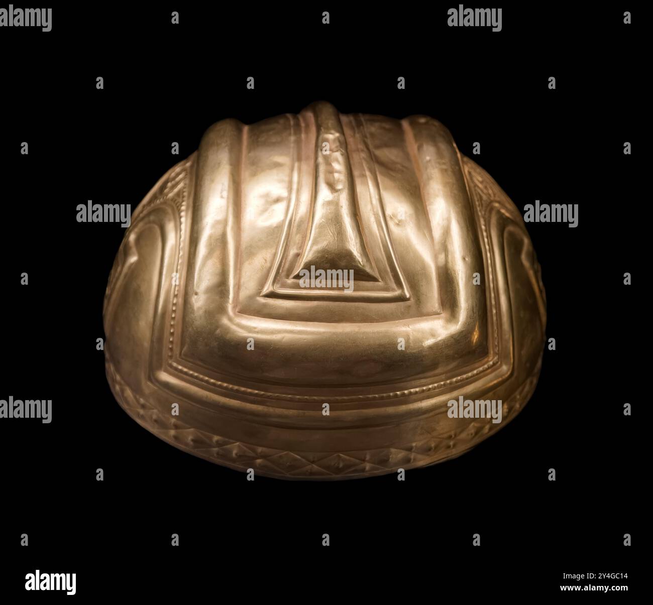 old gold antique Indian helmet from South America on a black background ...