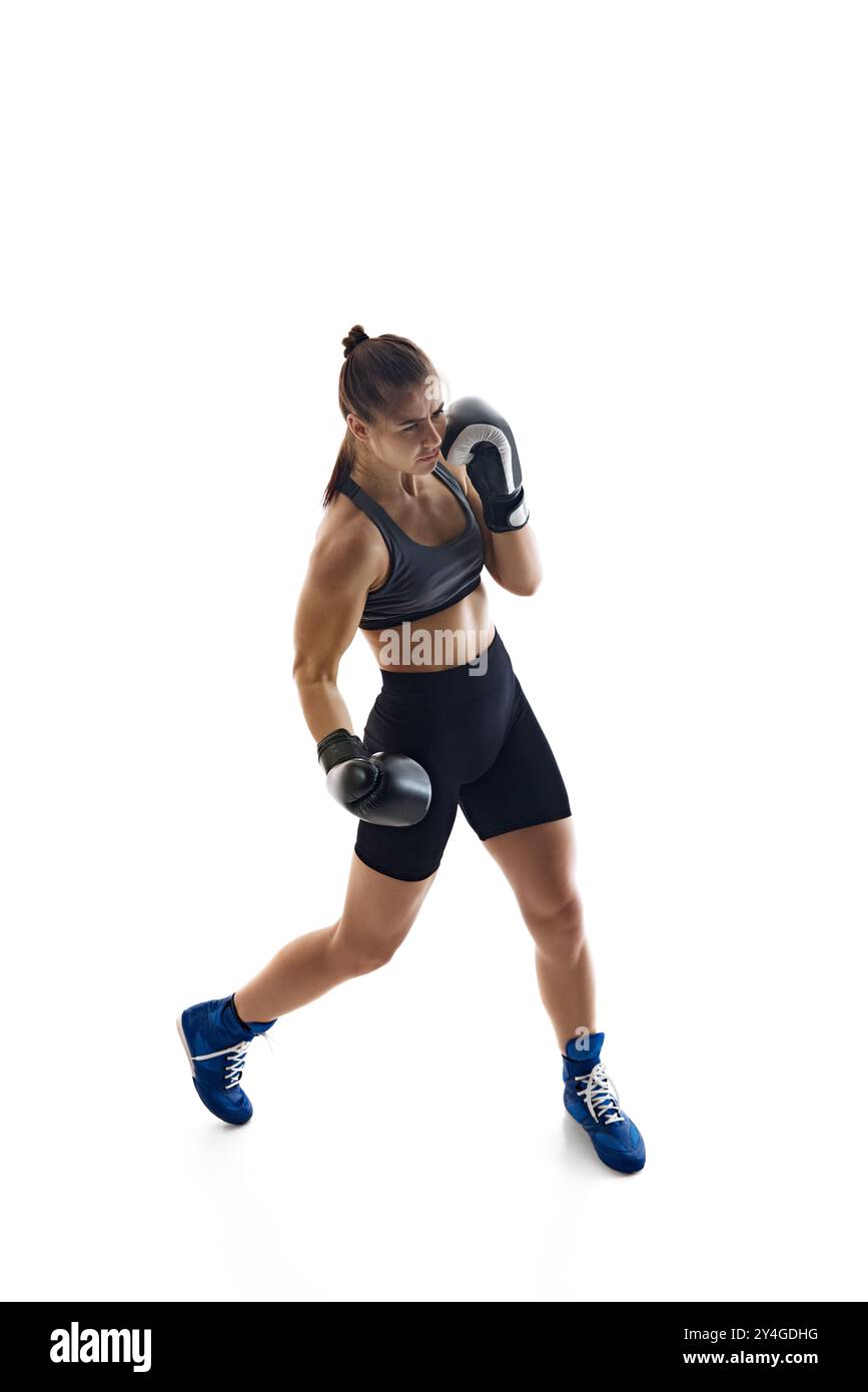 Uppercut. Full-length dynamic image of athletic young woman, training ...