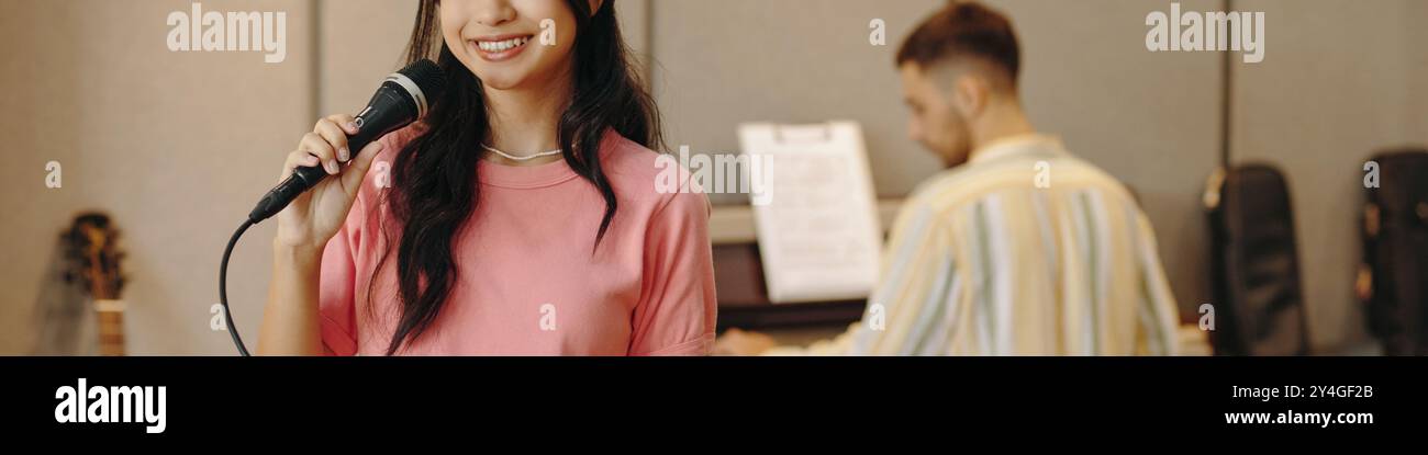 Young Woman Singing into Microphone in Music Studio Stock Photo - Alamy