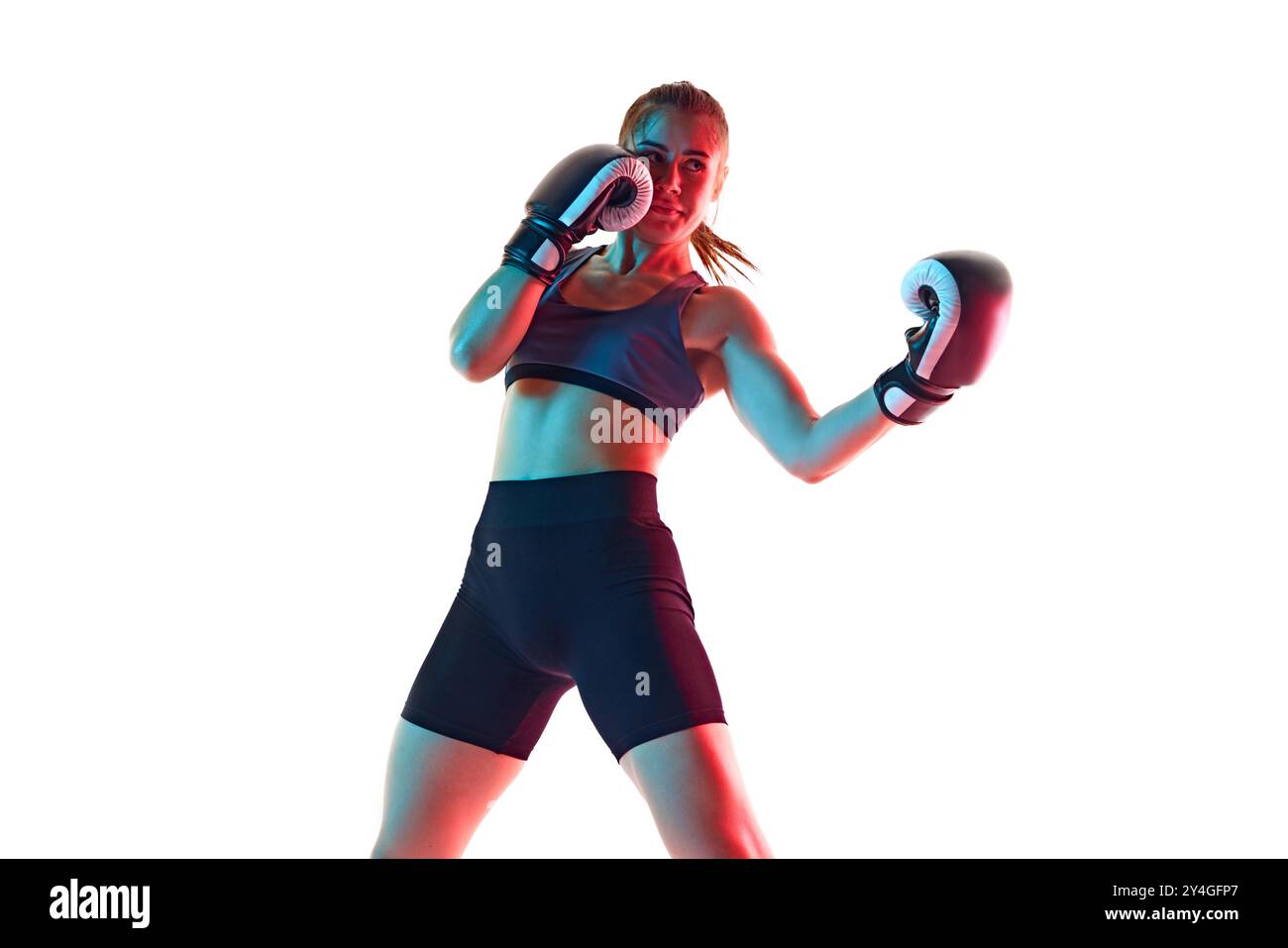 Uppercut punch. Concentrated young woman with fir sportive body, boxing ...