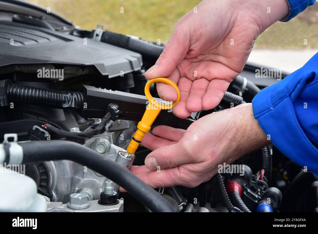 Checking the amount of oil in the car engine via the level control rod ...