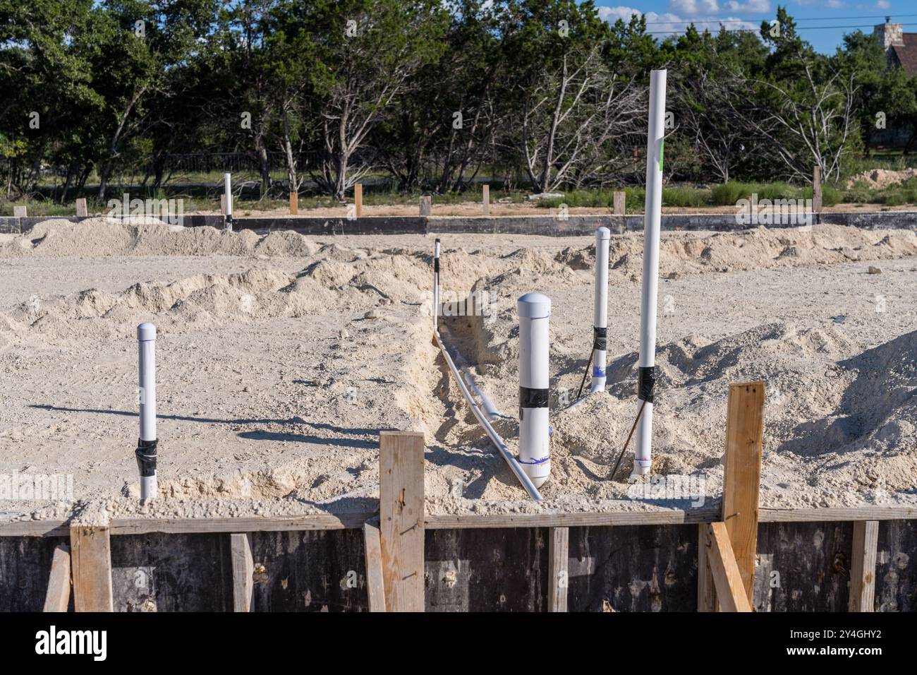 Trenches in the sand for plumbing and drain pipework before adding ...