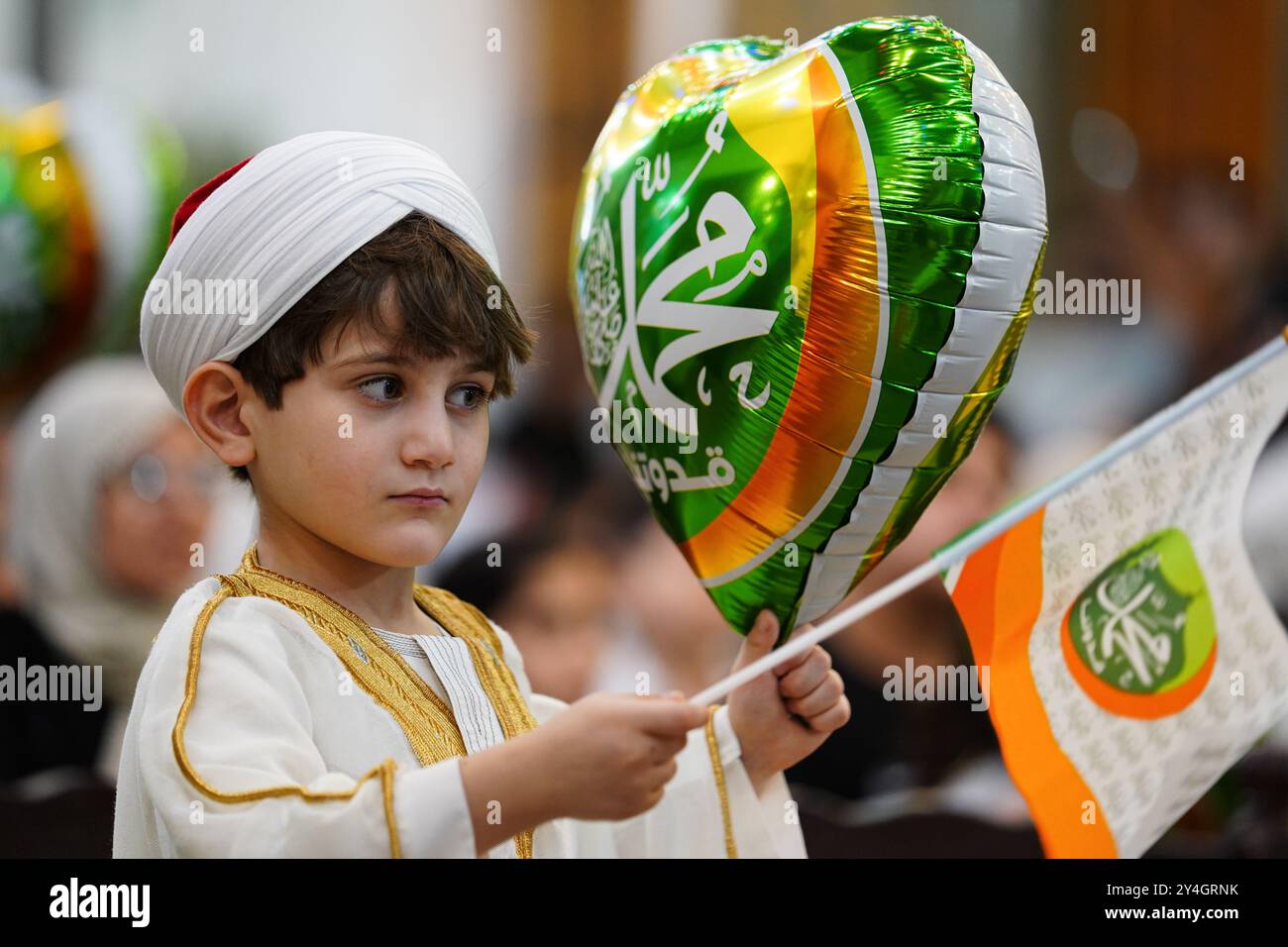 A child wearing traditional costume participates in a celebration of ...