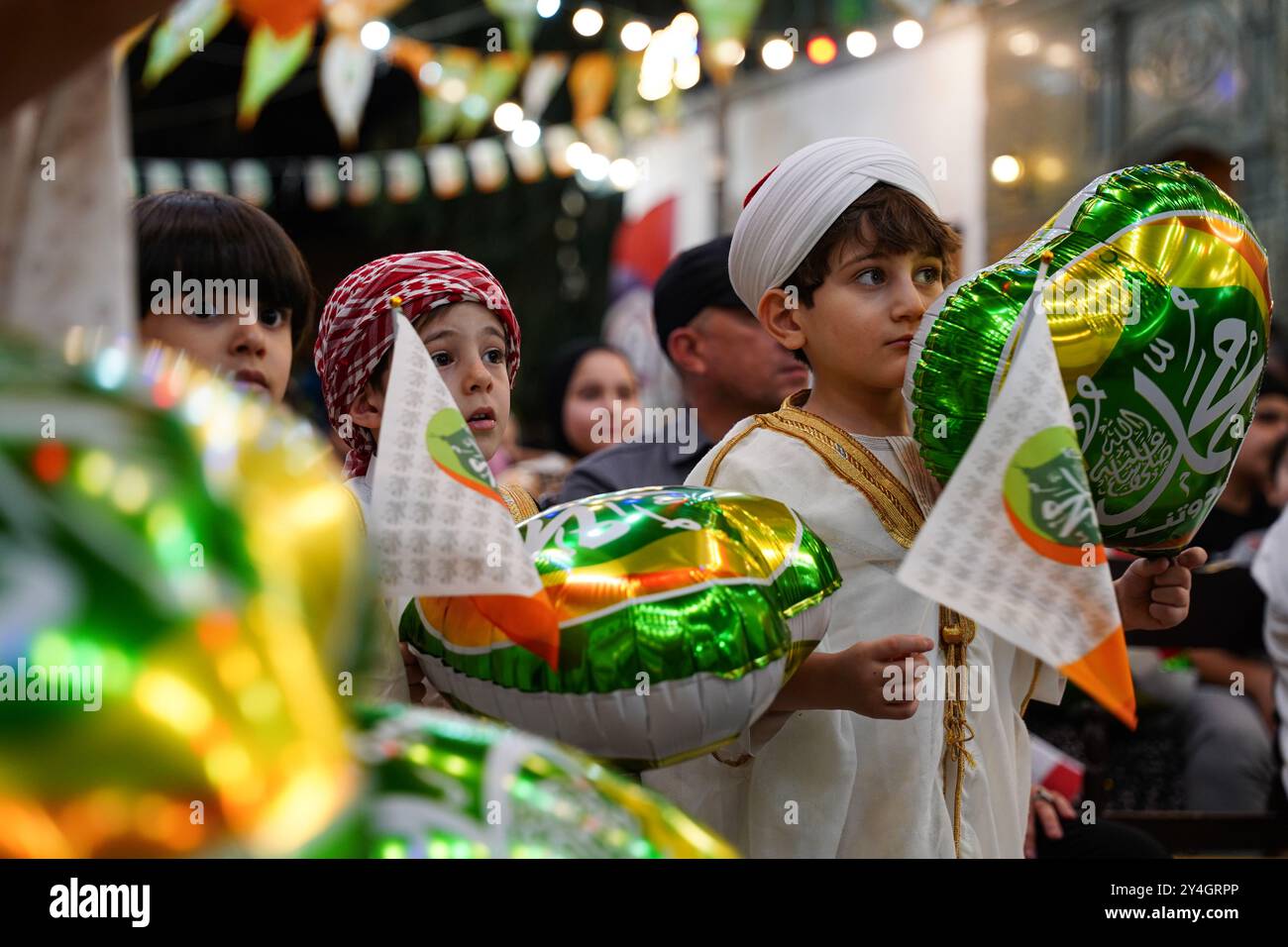 Children wearing traditional costumes participate in a celebration of ...