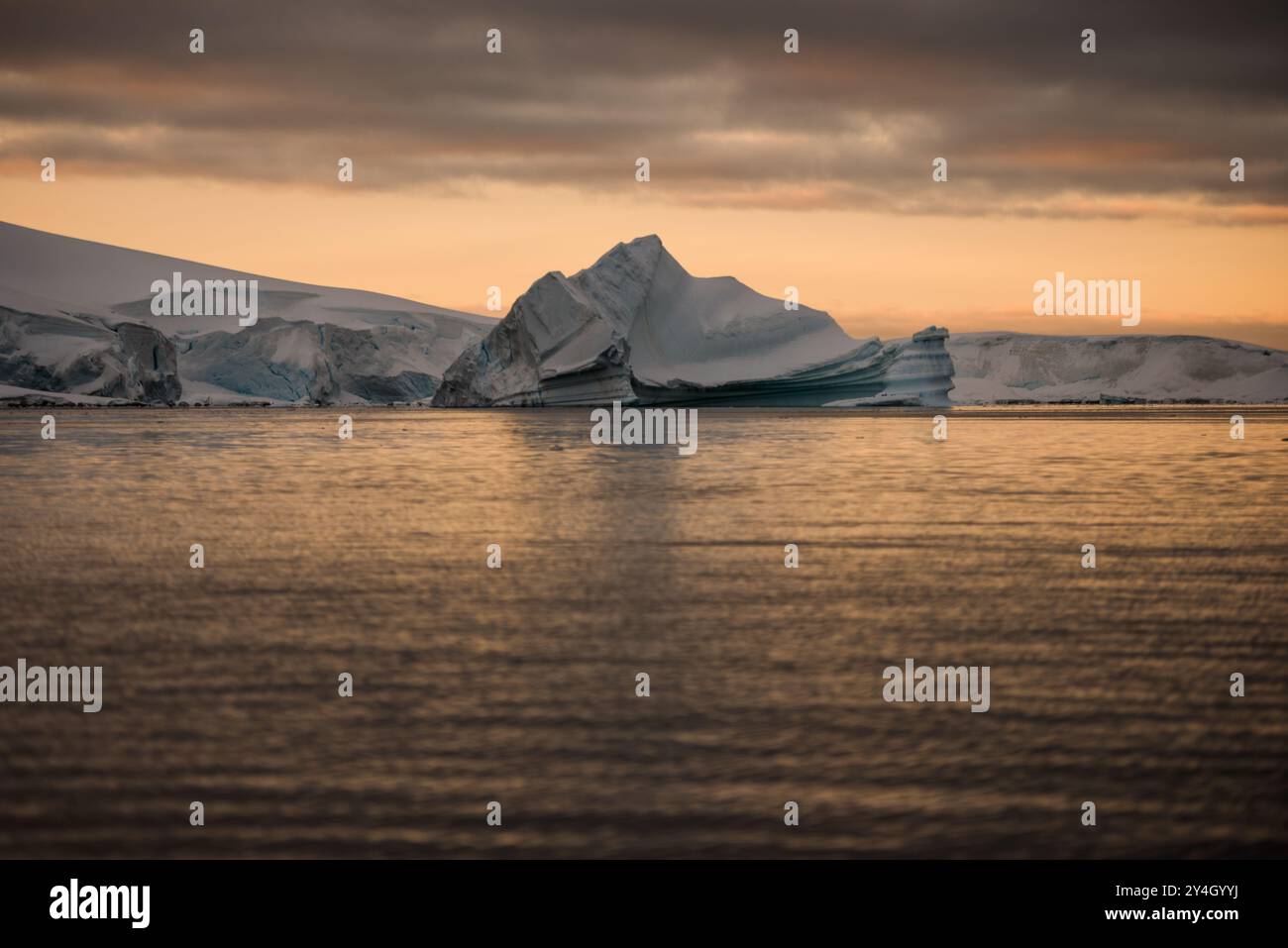 HUGHES BAY, Antarctica — An iceberg floats in the calm waters of Hughes ...