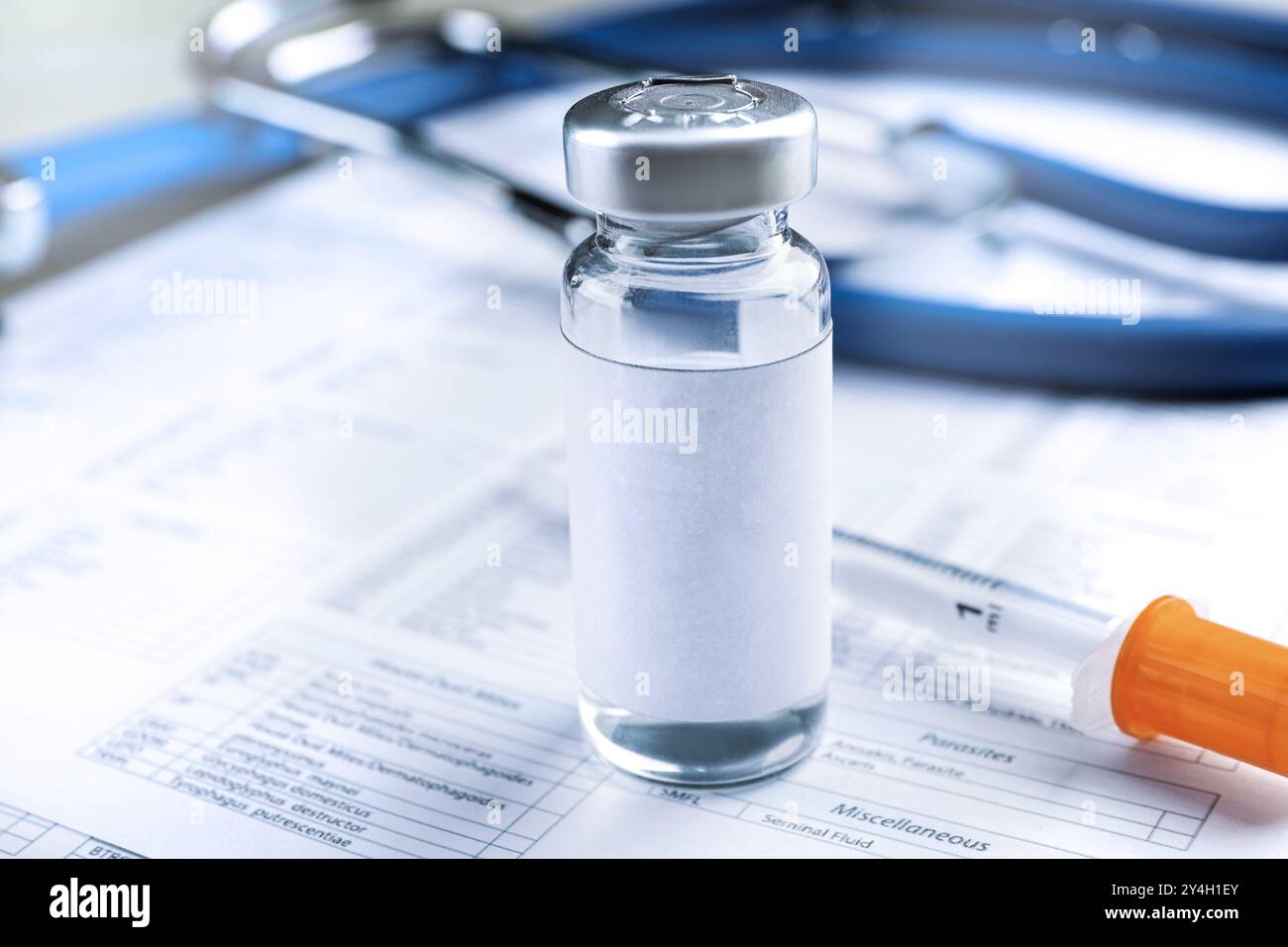 Medication in vial with blank label and syringe on medical form ...