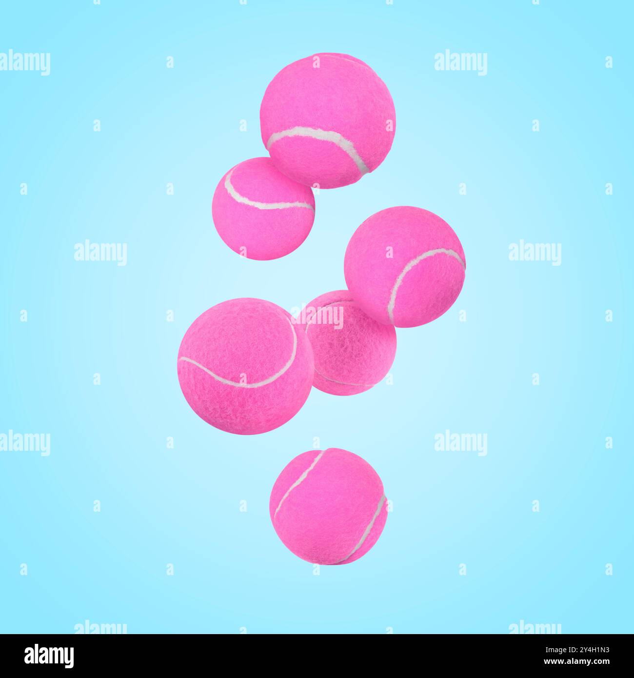 Many pink tennis balls in air on light blue background Stock Photo - Alamy