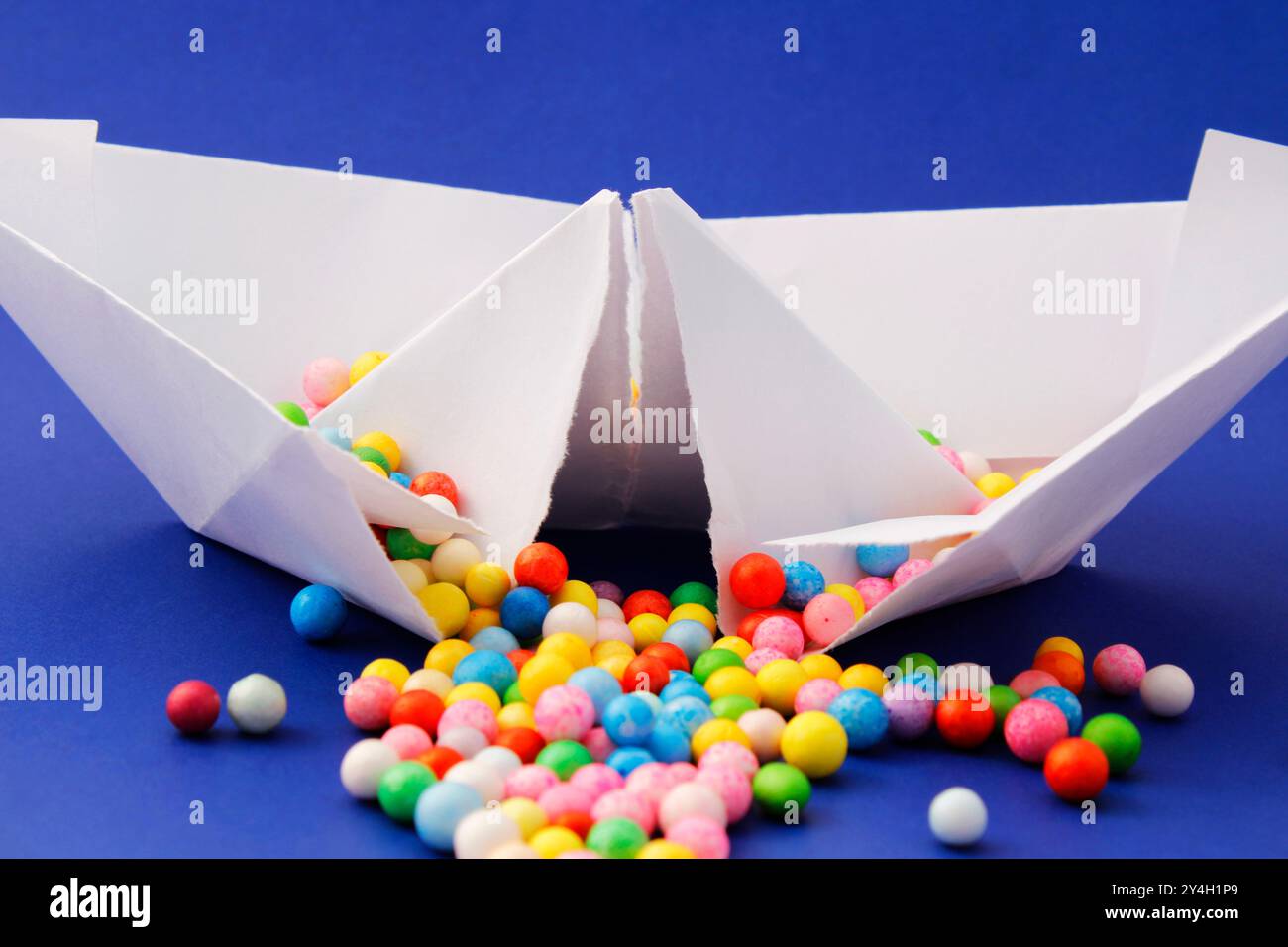 Broken paper boat loses cargo of colorful spheres Stock Photo - Alamy