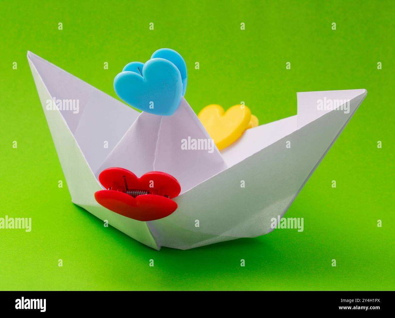 Colorful heart shaped clips repairing a paper boat Stock Photo - Alamy