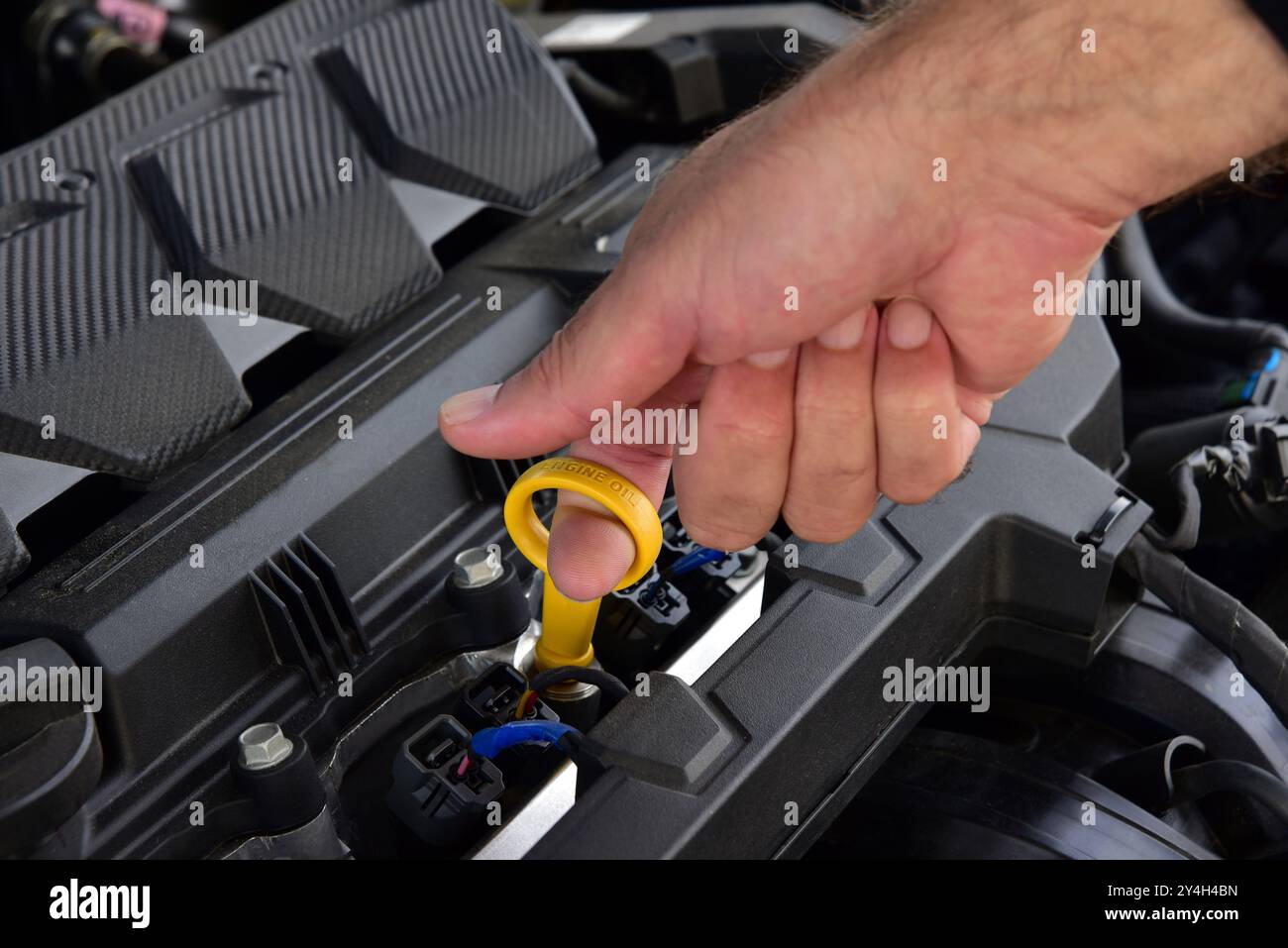 Checking the amount of oil in the car engine via the level control rod ...