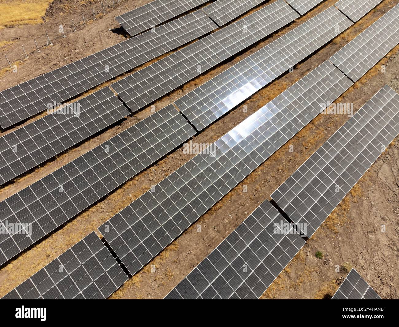 A drone captures an aerial view of rows of solar panels installed in a ...