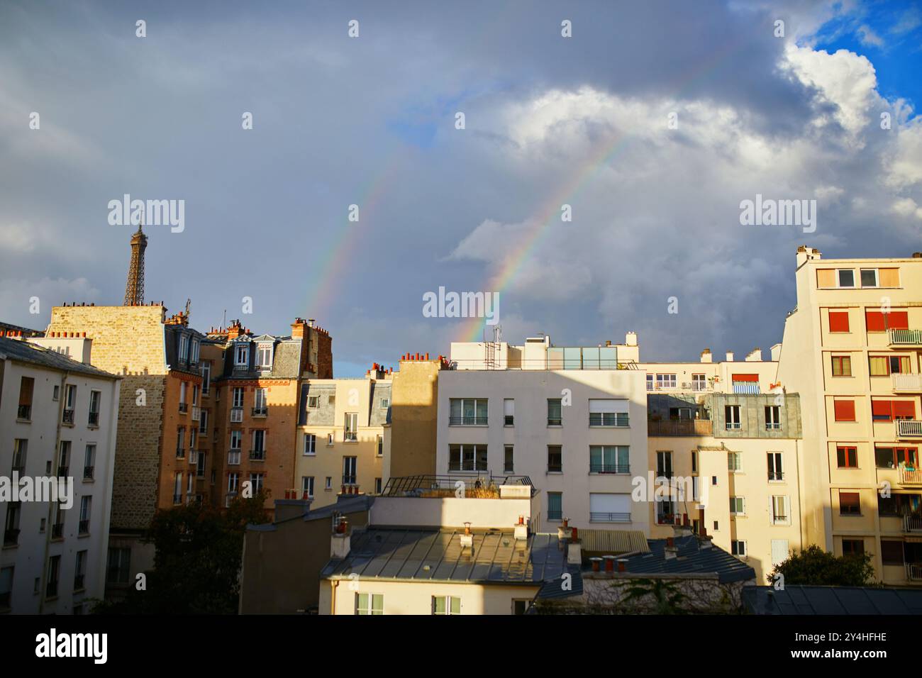 Scenic view of the Eiffel tower with rainbow over the roofs of ...