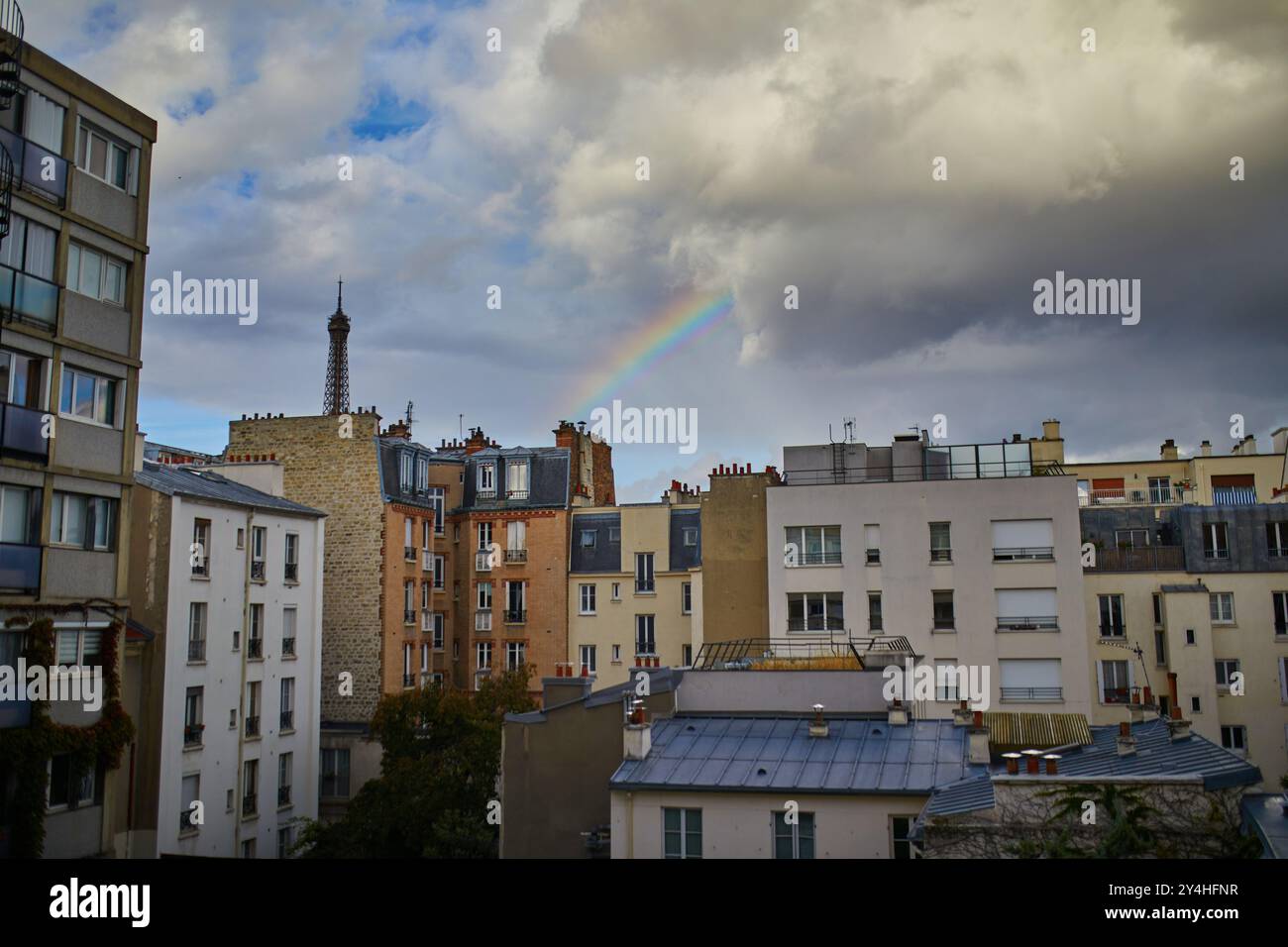 Scenic view of the Eiffel tower with rainbow over the roofs of ...