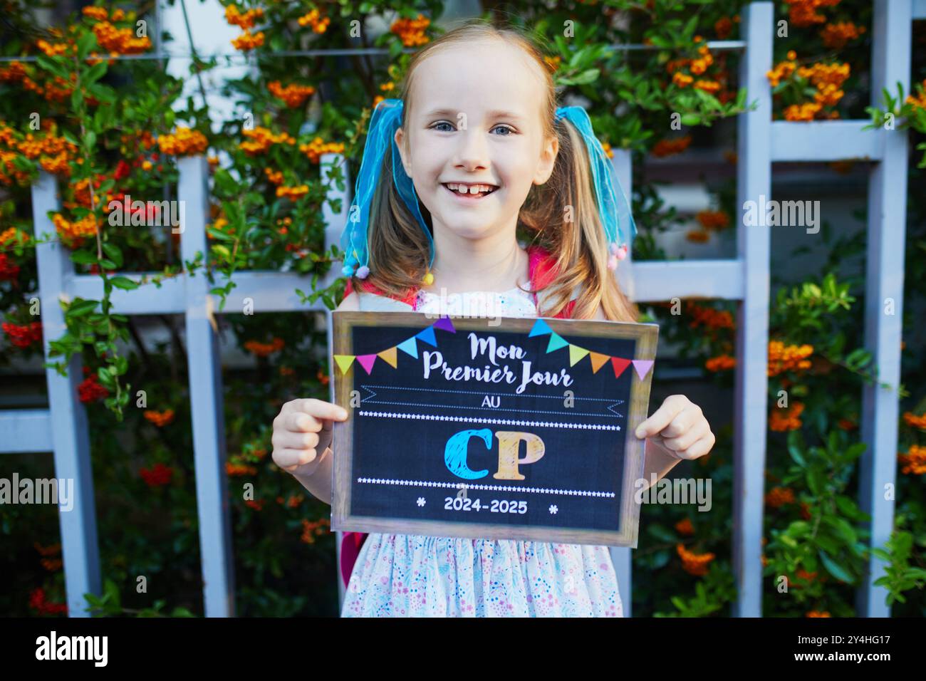 Cheerful 6 years old girl holding a poster with text My first day in ...