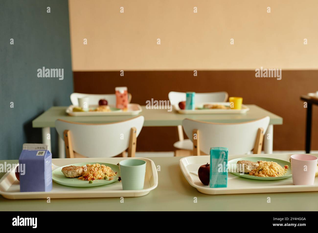 Inside empty school cafeteria with trays on dining tables, where fresh ...