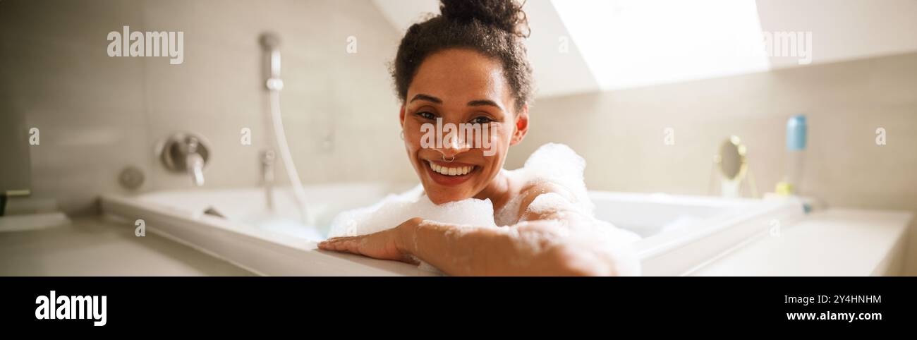 The woman is happily bathing in a jacuzzi tub, smiling with joy Stock ...