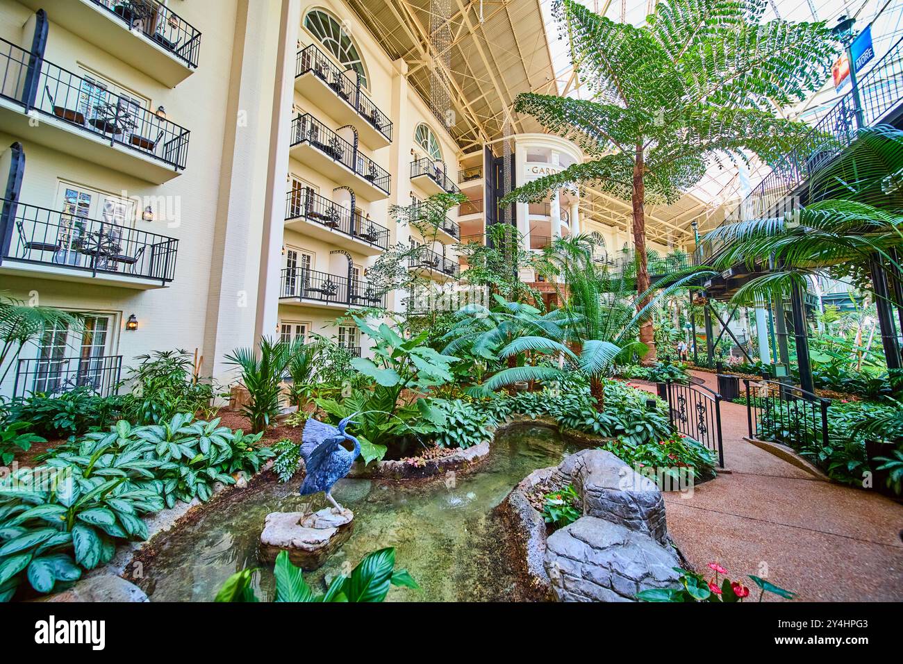 Tropical Hotel Atrium with Heron Statue and Stream Eye-Level View Stock ...