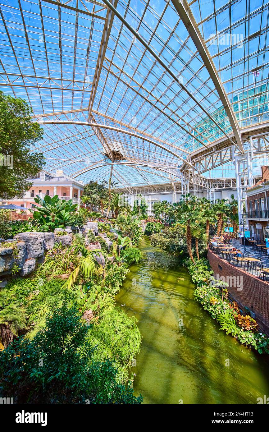 Tropical Oasis in Glass Atrium with Waterway and Greenery Elevated View ...