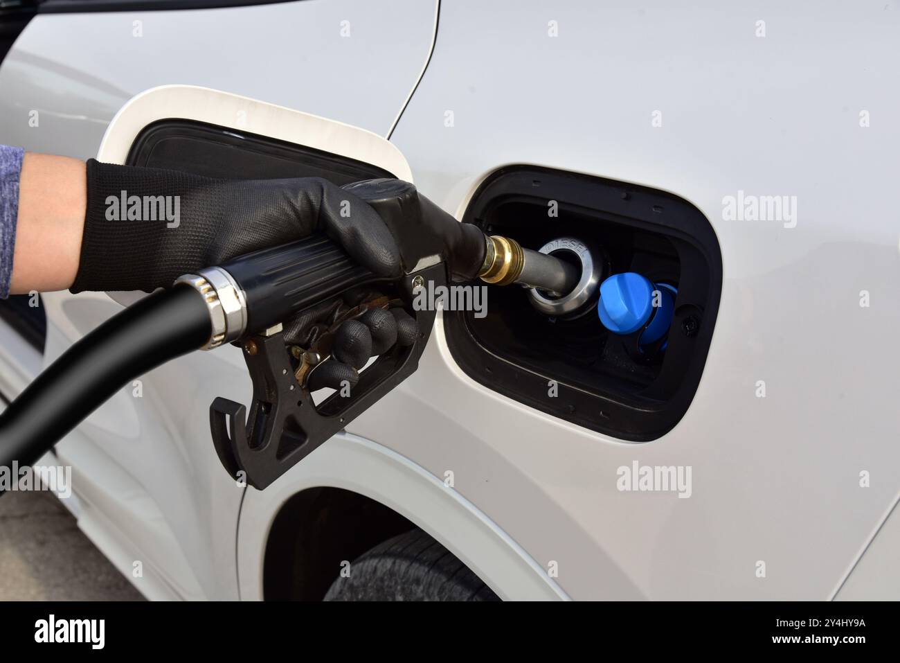 Refueling gun in tank filler. Fuel Nozzle in tank filler. Fuel pump in ...