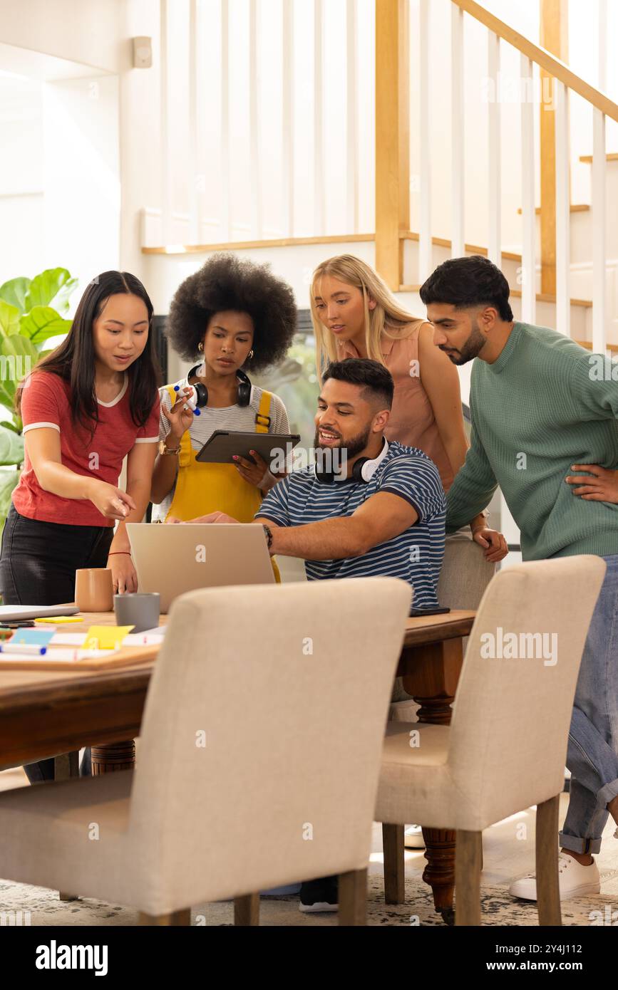 Collaborating on project, group of young friends using laptop and ...