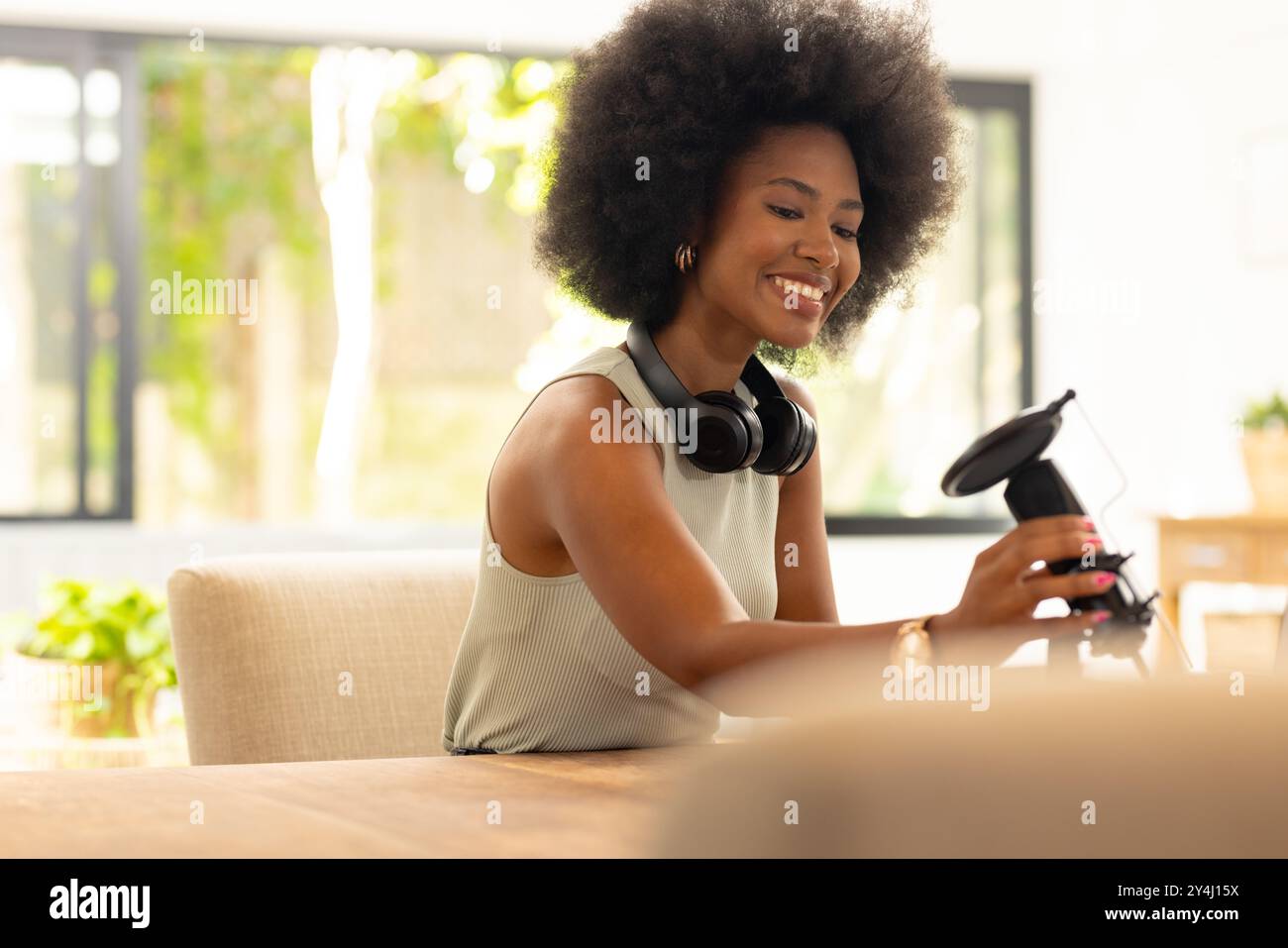 Adjusting microphone, smiling african american woman with headphones ...