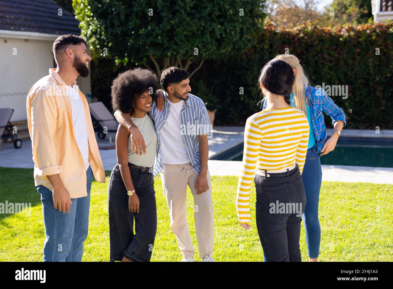 Standing together outside, friends enjoying conversation by pool Stock ...