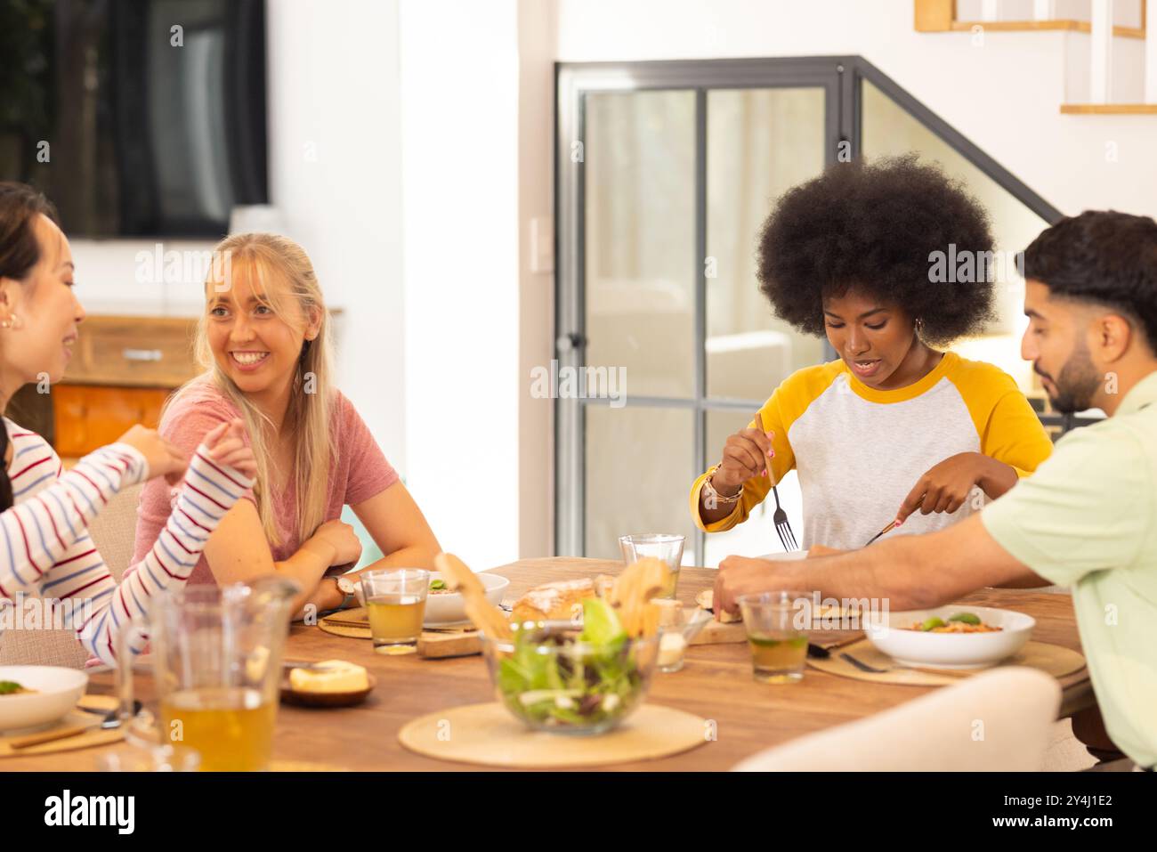 Eating lunch together, group of young diverse friends enjoying meal at ...