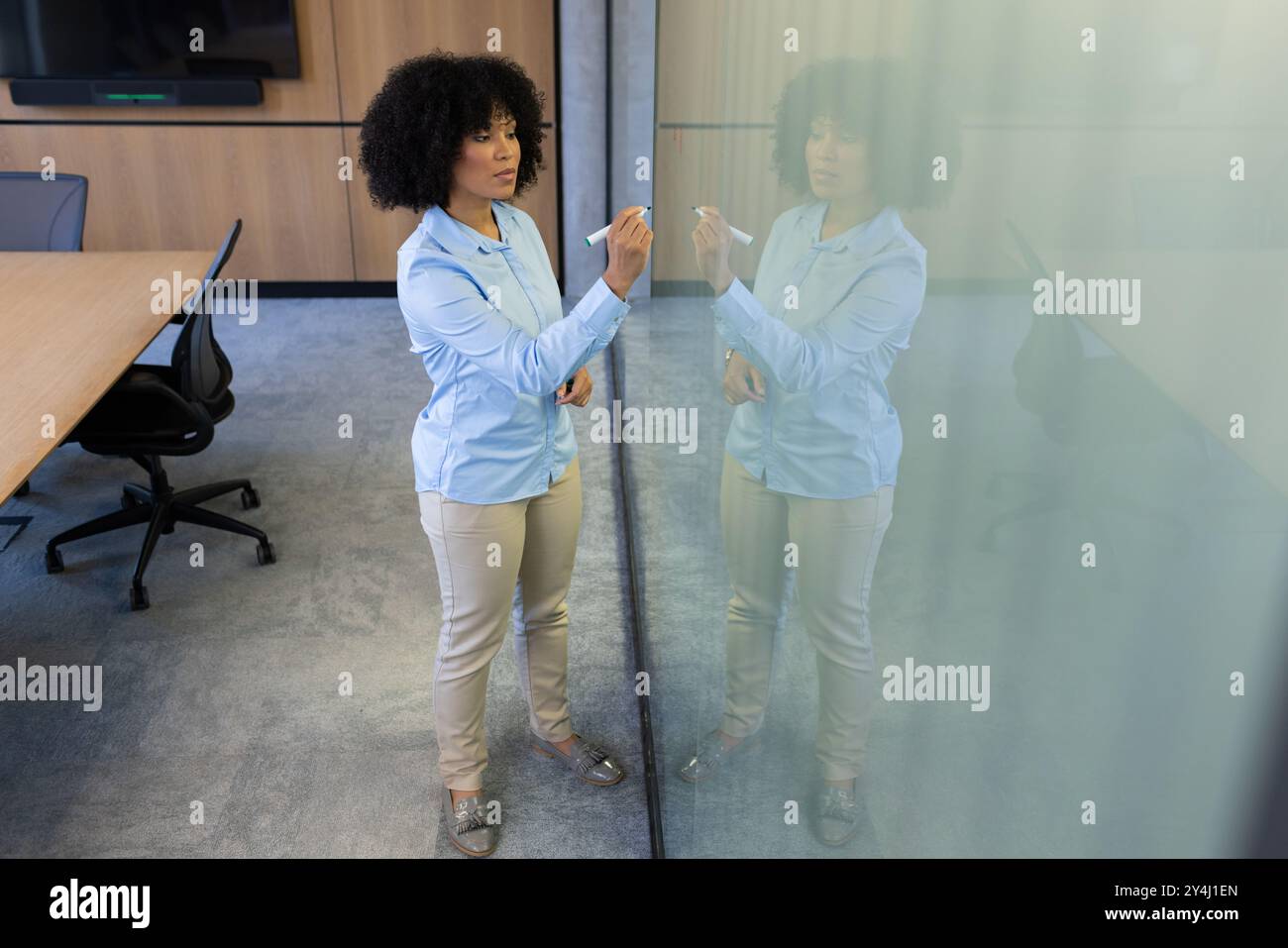 Writing on glass board, businesswoman brainstorming ideas in modern ...