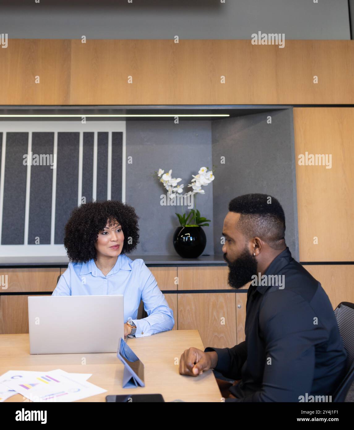 Business meeting, colleagues discussing project at table with laptop ...