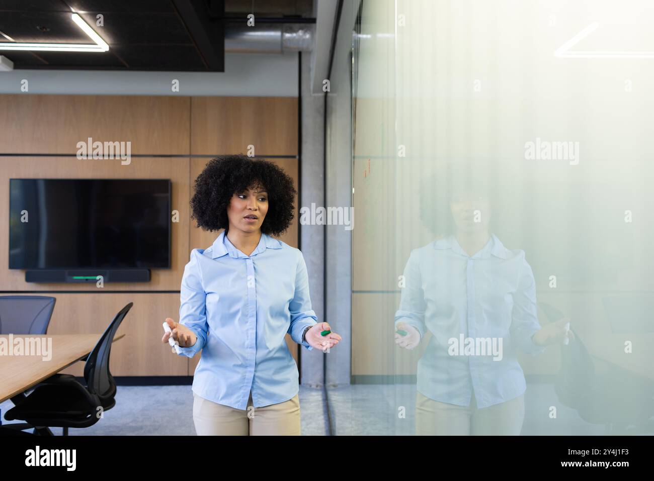 Presenting in modern office, woman standing and gesturing during ...